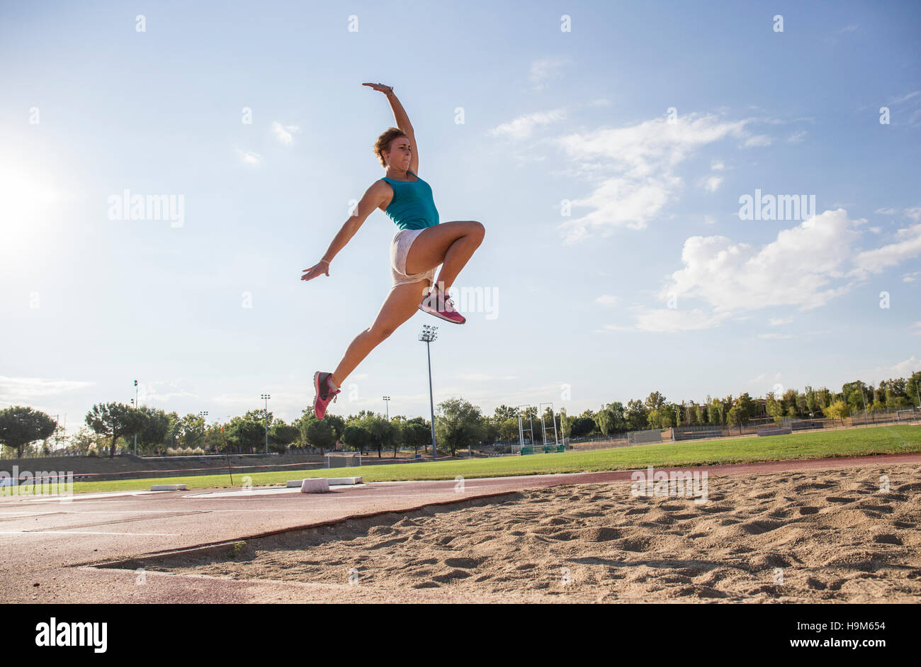 Female long jumper mid-air Stock Photo - Alamy