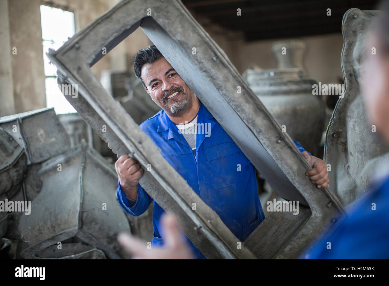 Smiling man working in industrial pot factory Stock Photo - Alamy