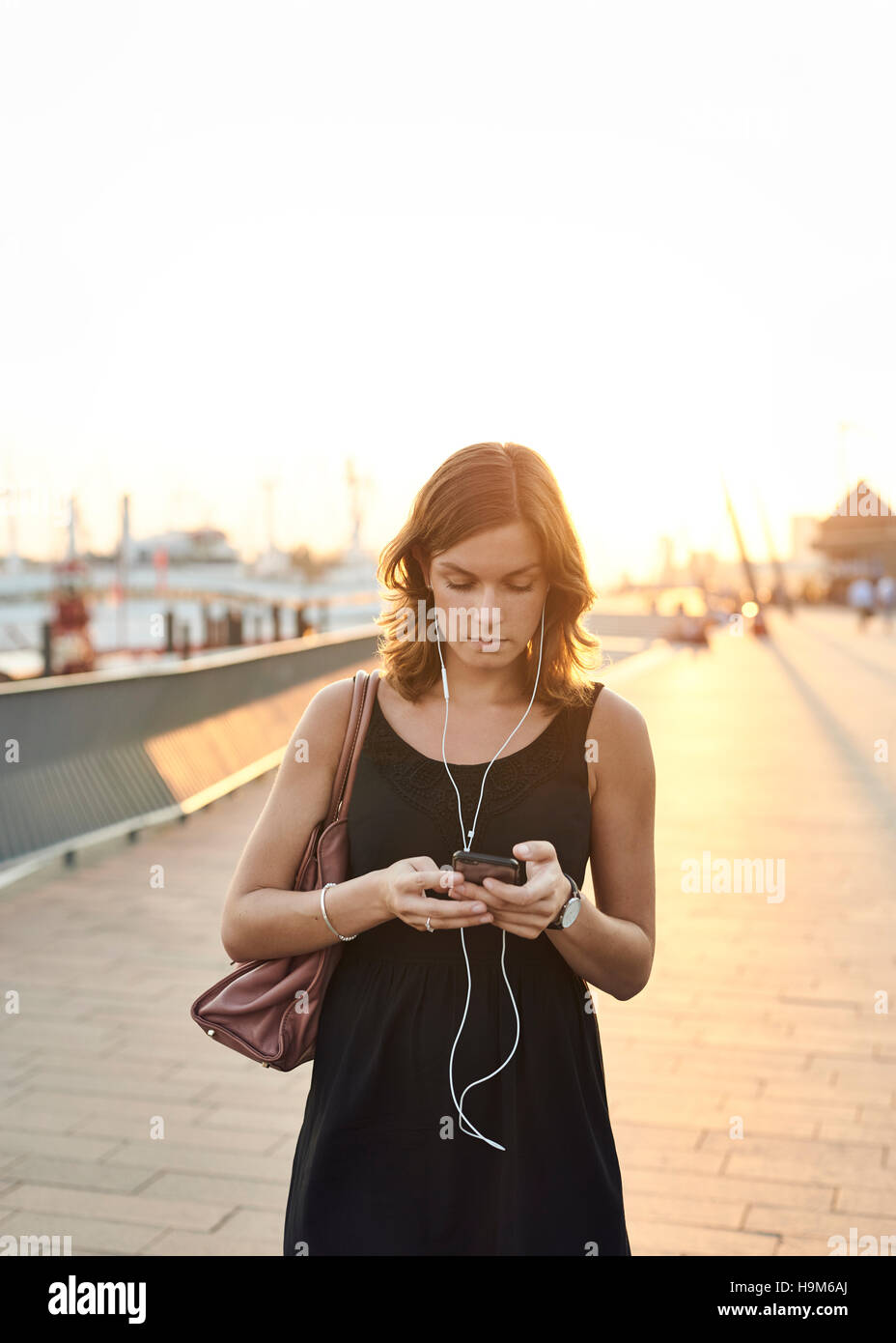 Germany, Young woman with smart phone exploring Hamburg Stock Photo - Alamy