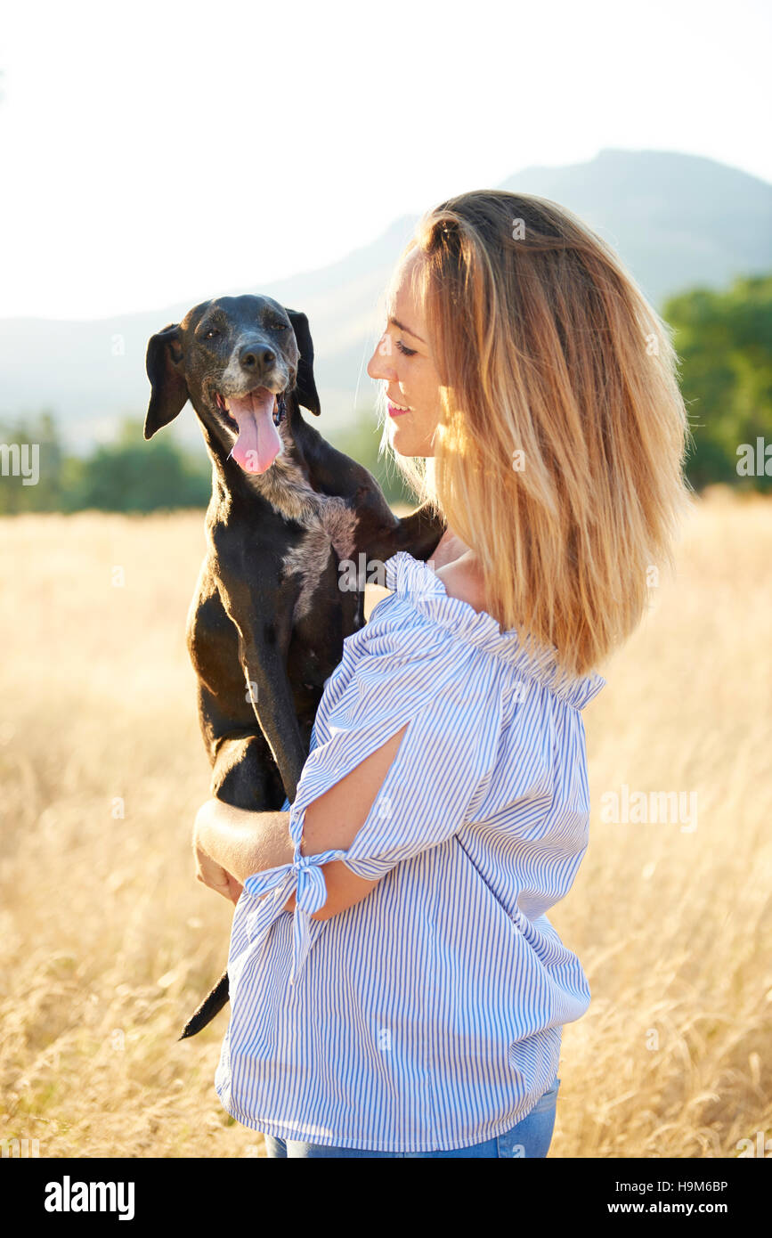 Happy woman with her dog in nature Stock Photo - Alamy