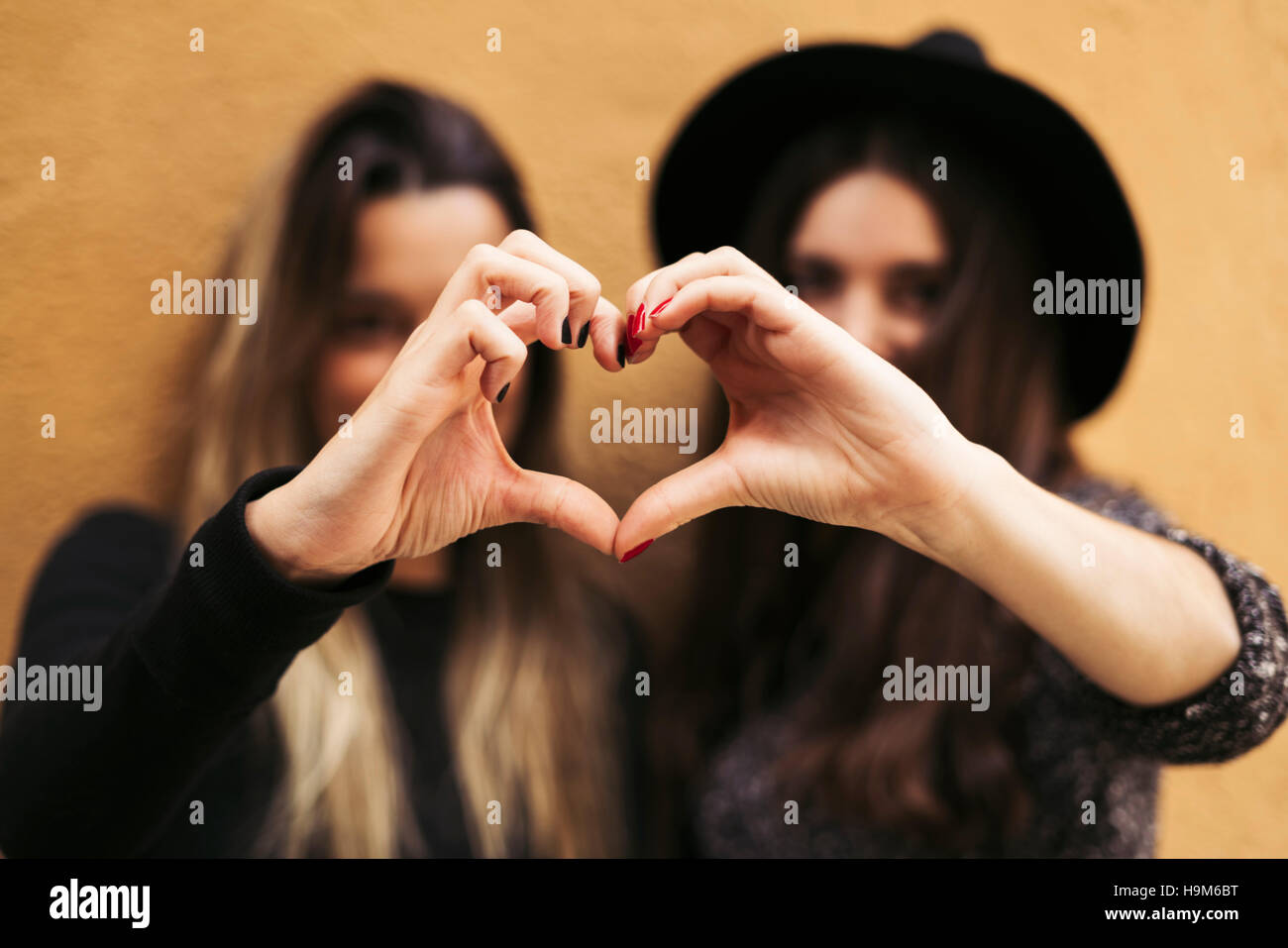 Two women shaping hands to a heart Stock Photo - Alamy