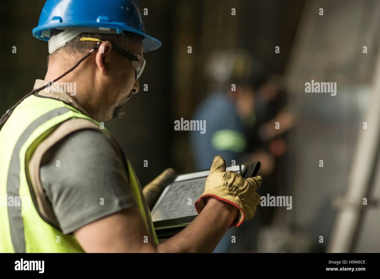 Engineer looking at blueprint on digital tablet Stock Photo - Alamy
