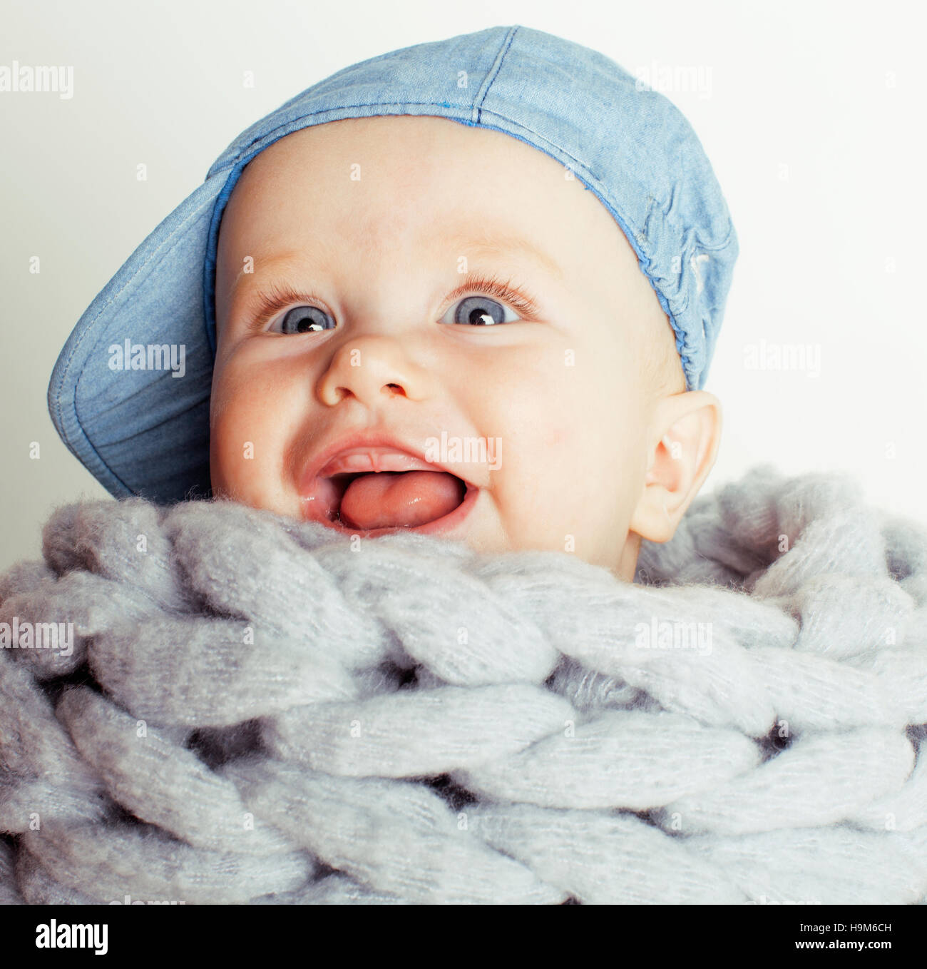 little cute red head baby in scarf all over him close up isolated ...