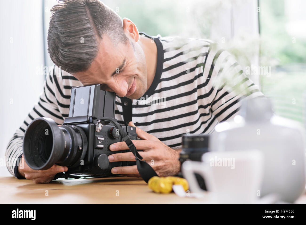 Man at home checking camera Stock Photo - Alamy