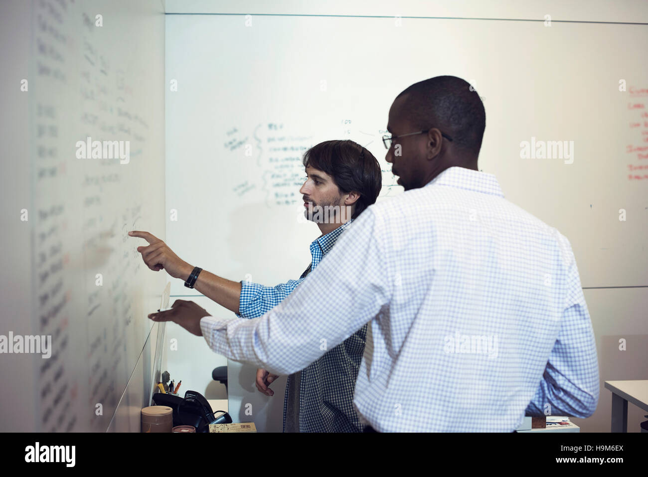 Business people writing on whiteboard in office Stock Photo - Alamy
