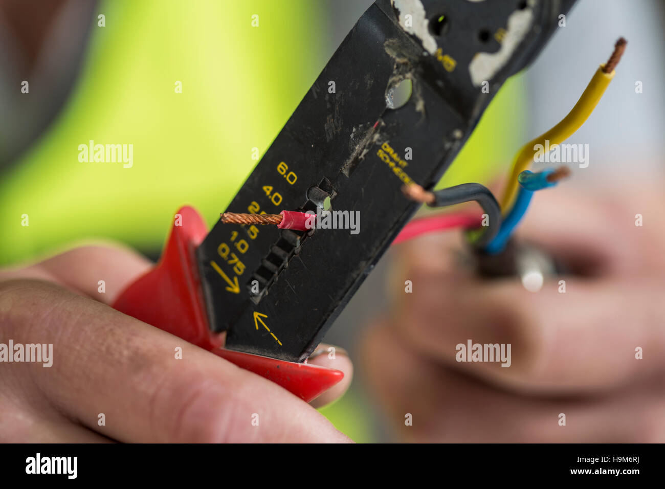 Electrician using wire stripper Stock Photo - Alamy