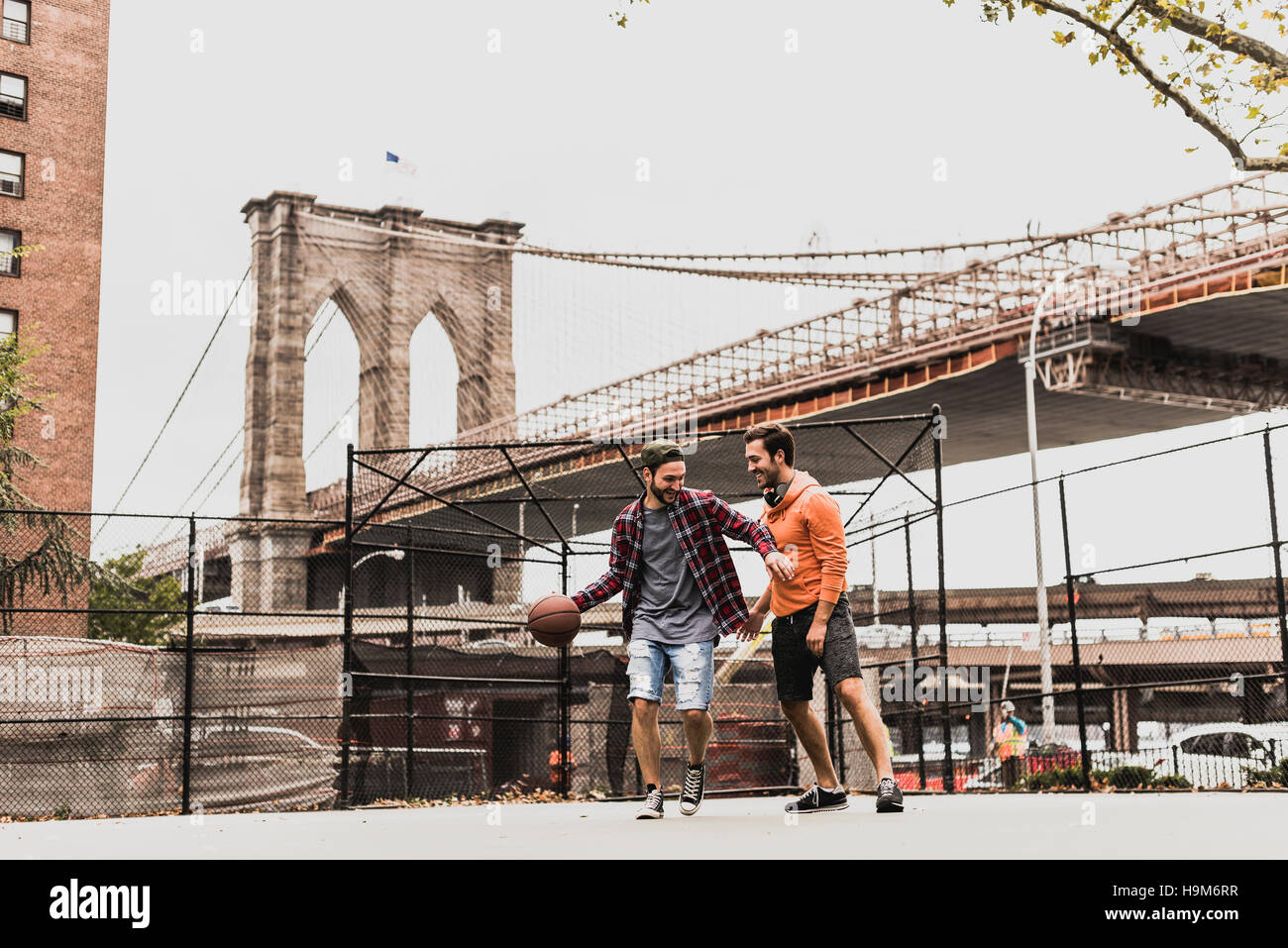USA, New York, two young men playing basketball on an outdoor court ... USA, New York, two young men playing basketball on an outdoor court ...