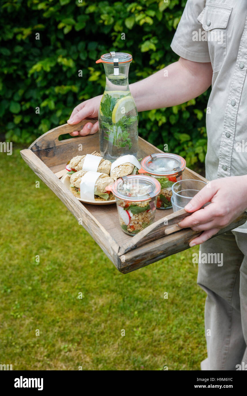 Person carrying tray with vegetarian snacks for picnic Stock Photo - Alamy