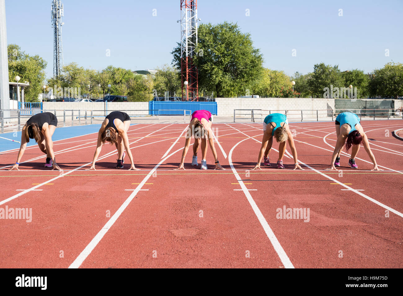 Female runners on tartan track in starting position Stock Photo - Alamy