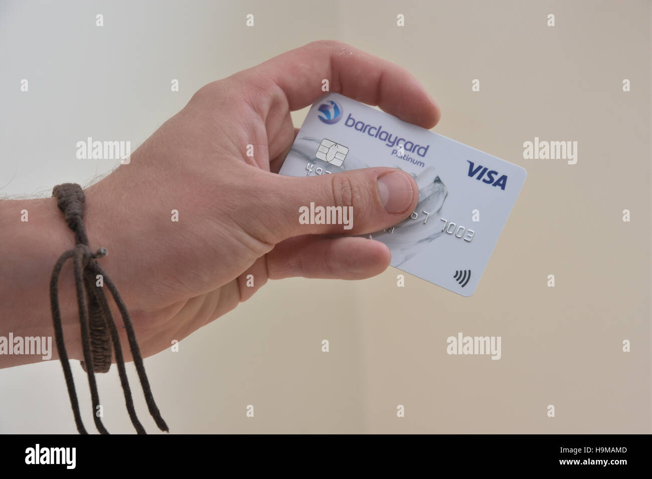 Close up of a teenage boy's hand holding a Barclaycard visa credit card ...