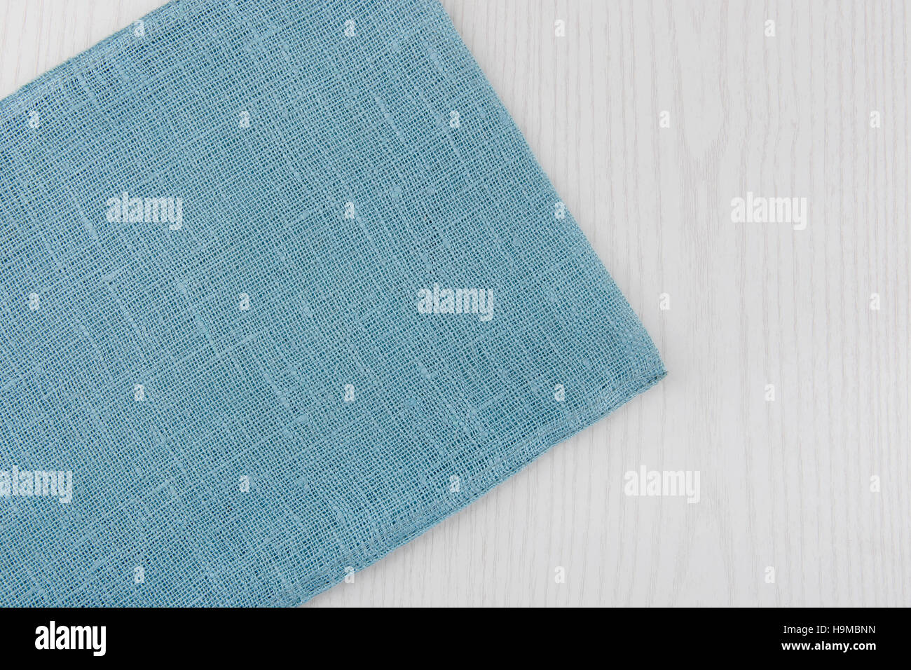 Napkin from left side wooden table. White blue background. Soft blue ...