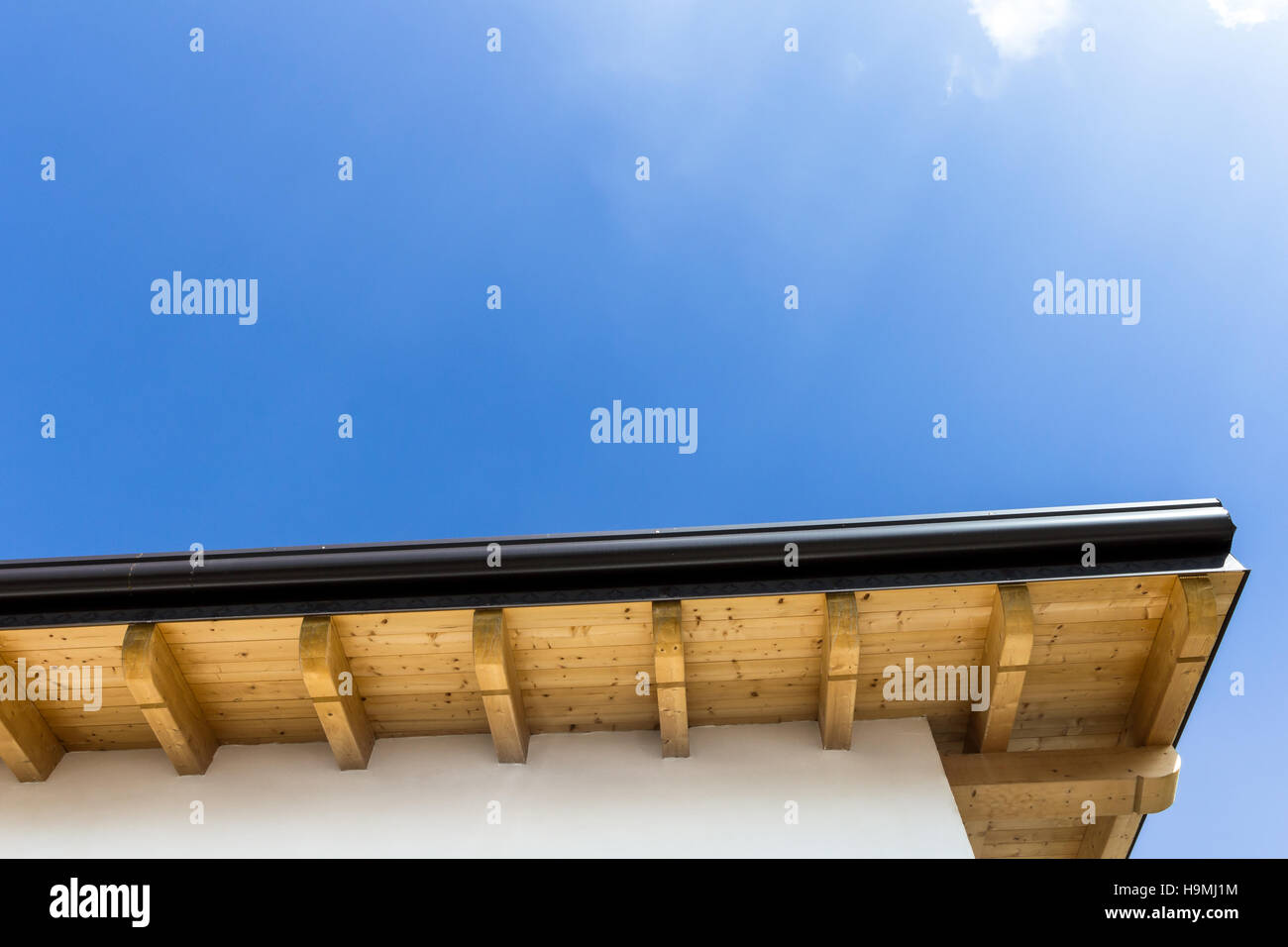 Low angle view of new house with wooden roof and gutter against clear ...