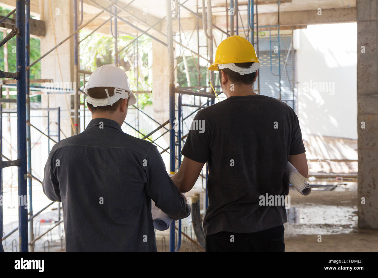 Engineer and Architect working at Construction Site with blueprint ...