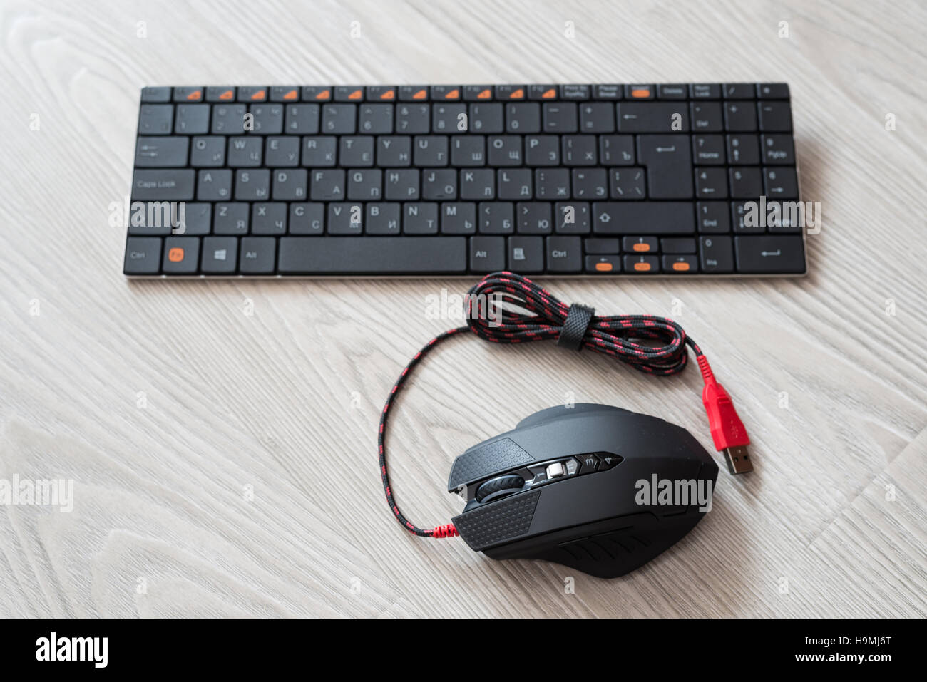 Top view of black computer mouse and keyboard with English and Russian ...