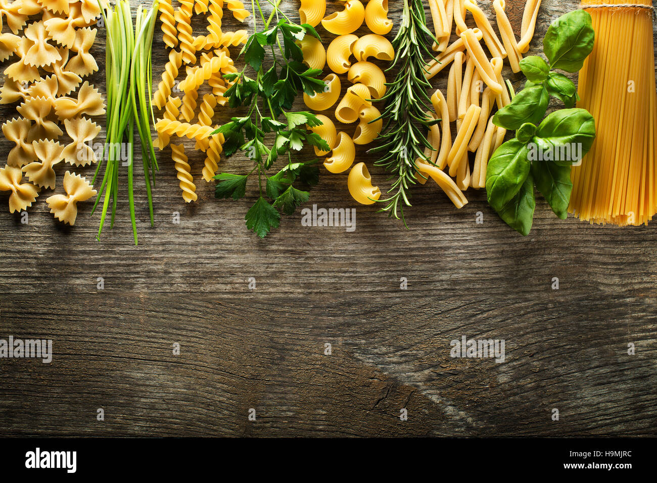 Pasta collection with herbs on rustic wooden background Stock Photo - Alamy