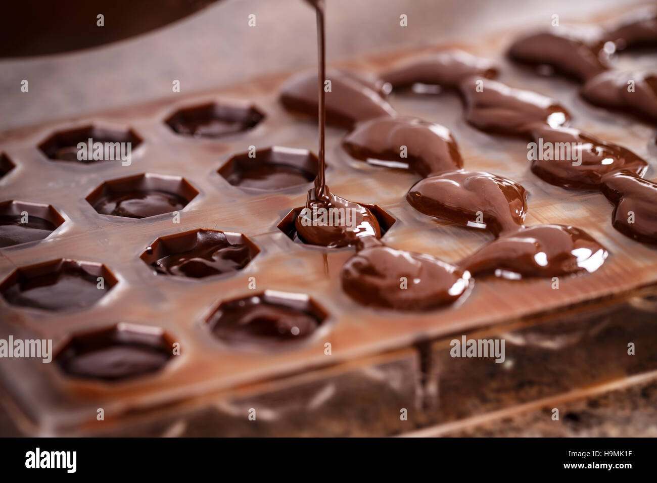 Putting chocolate in mold Stock Photo - Alamy