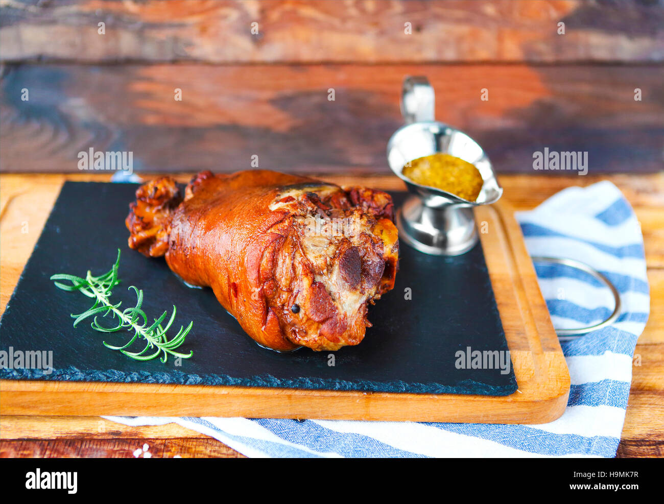 Roasted pork leg (rulka) served with garlic sauce on the wooden table ...