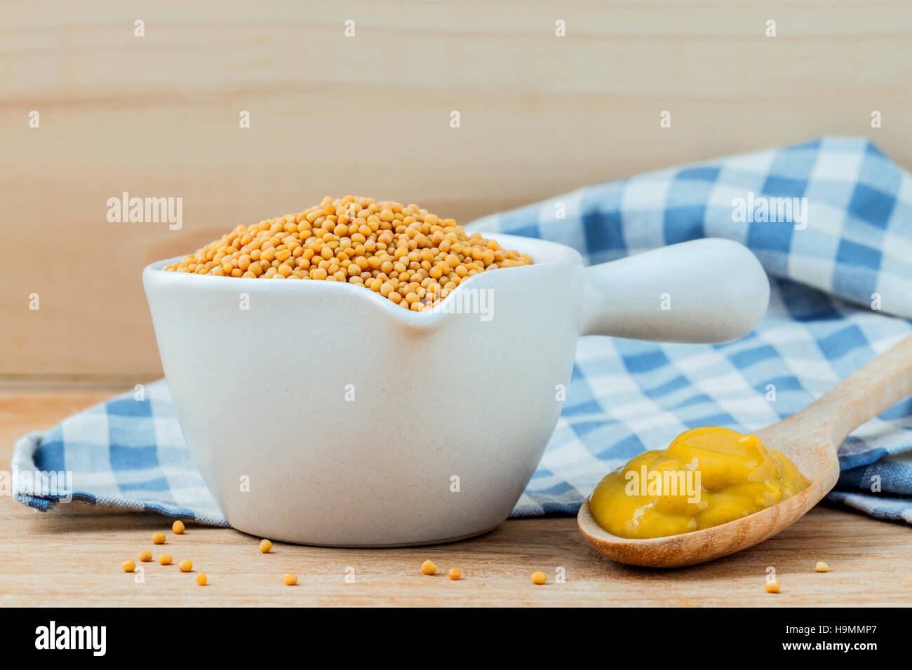 Composition of mustard and mustard seeds on wooden background Stock ...