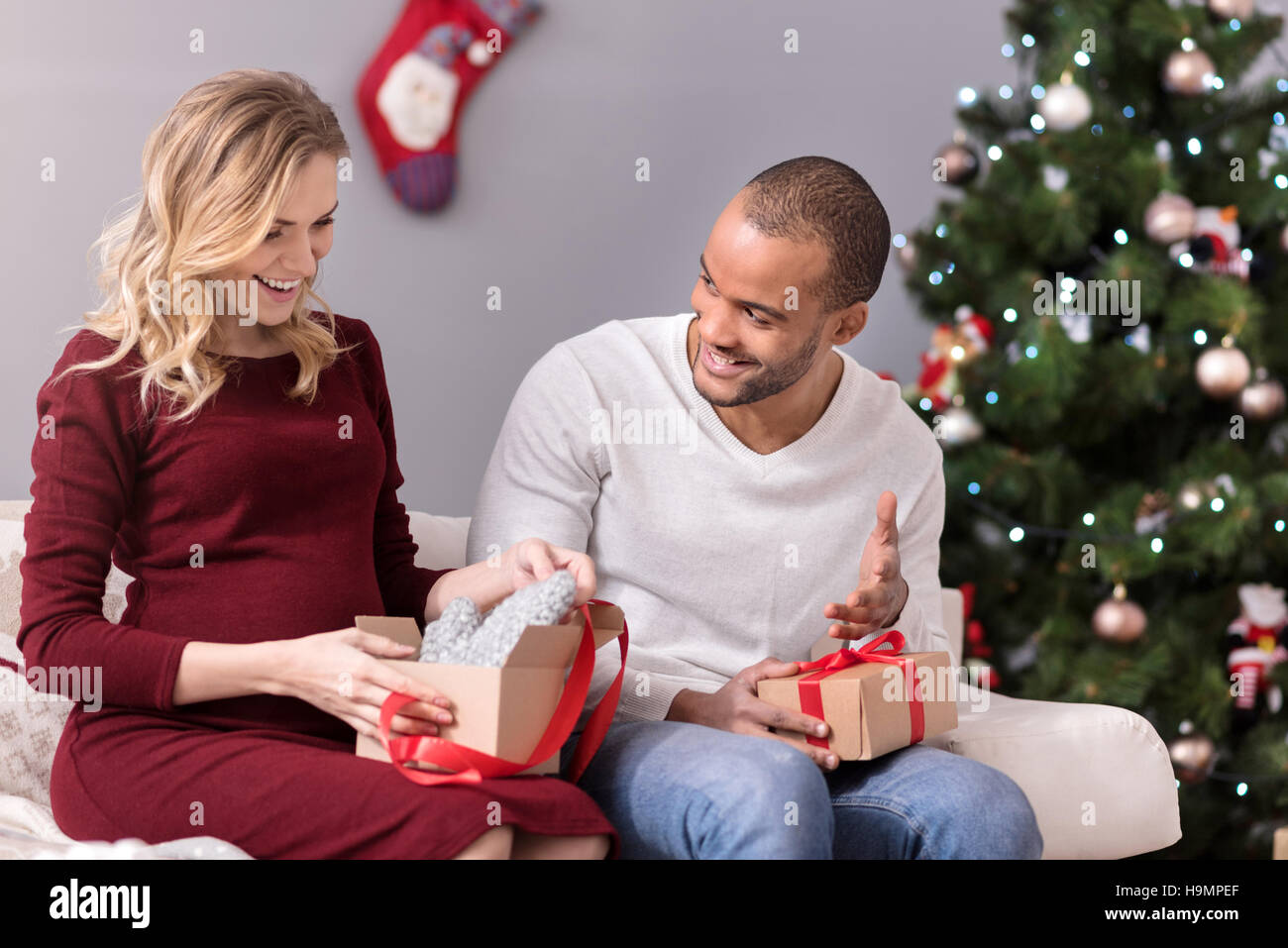 Cheerful nice couple opening their presents Stock Photo - Alamy