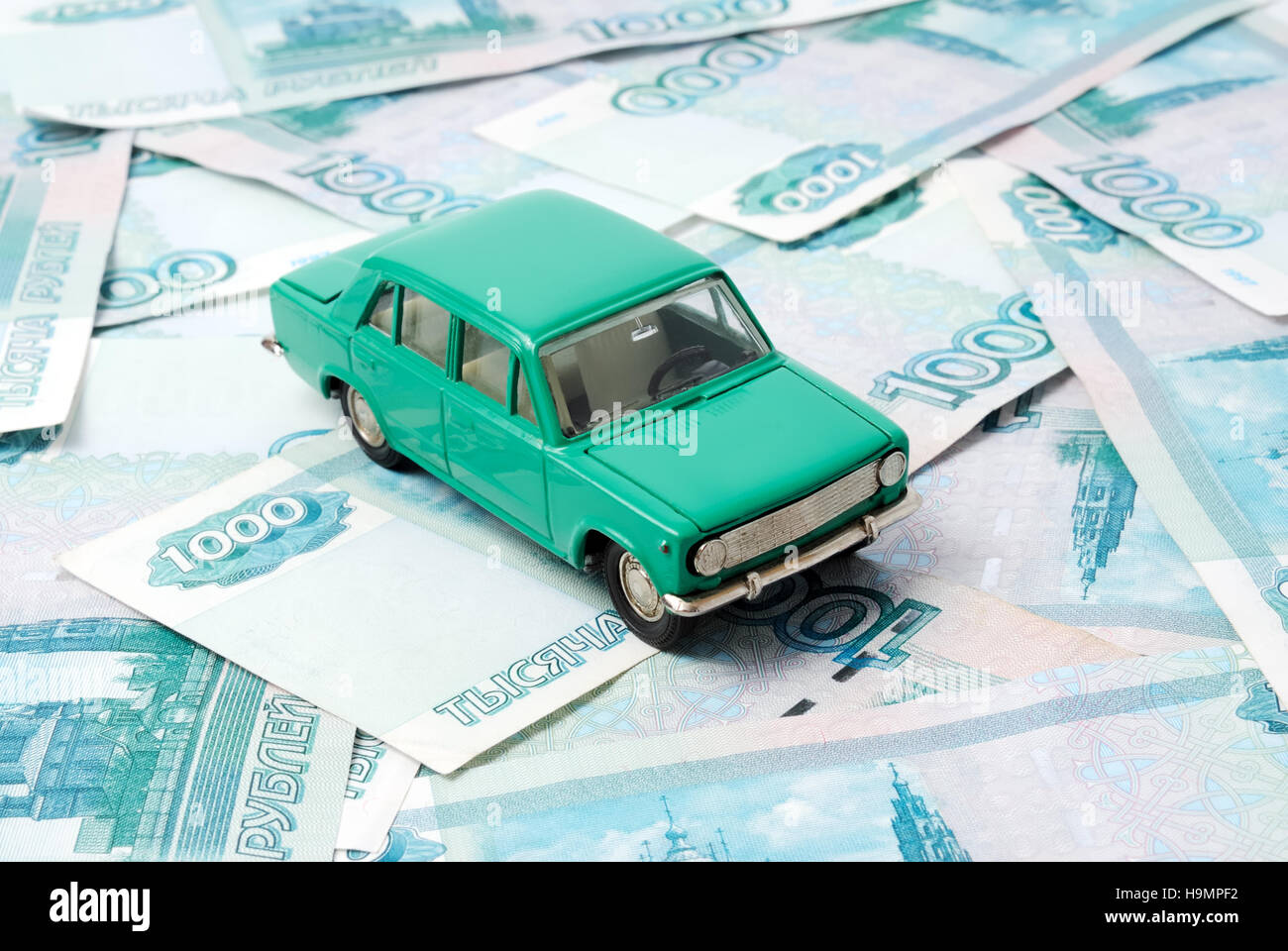 Toy car on the background of banknotes Stock Photo - Alamy