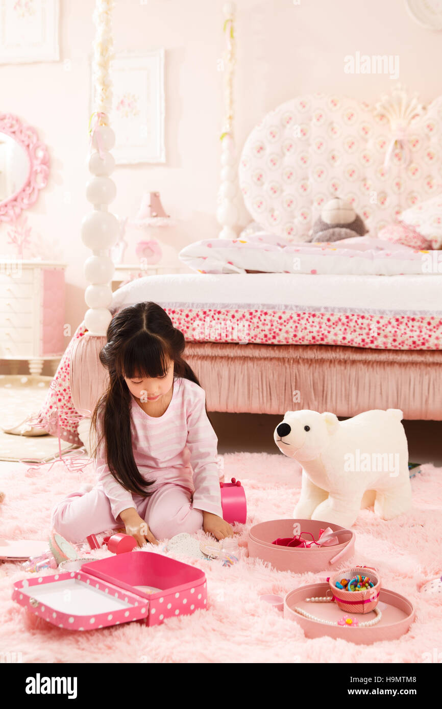 Cute little girl sitting on the rug Stock Photo - Alamy