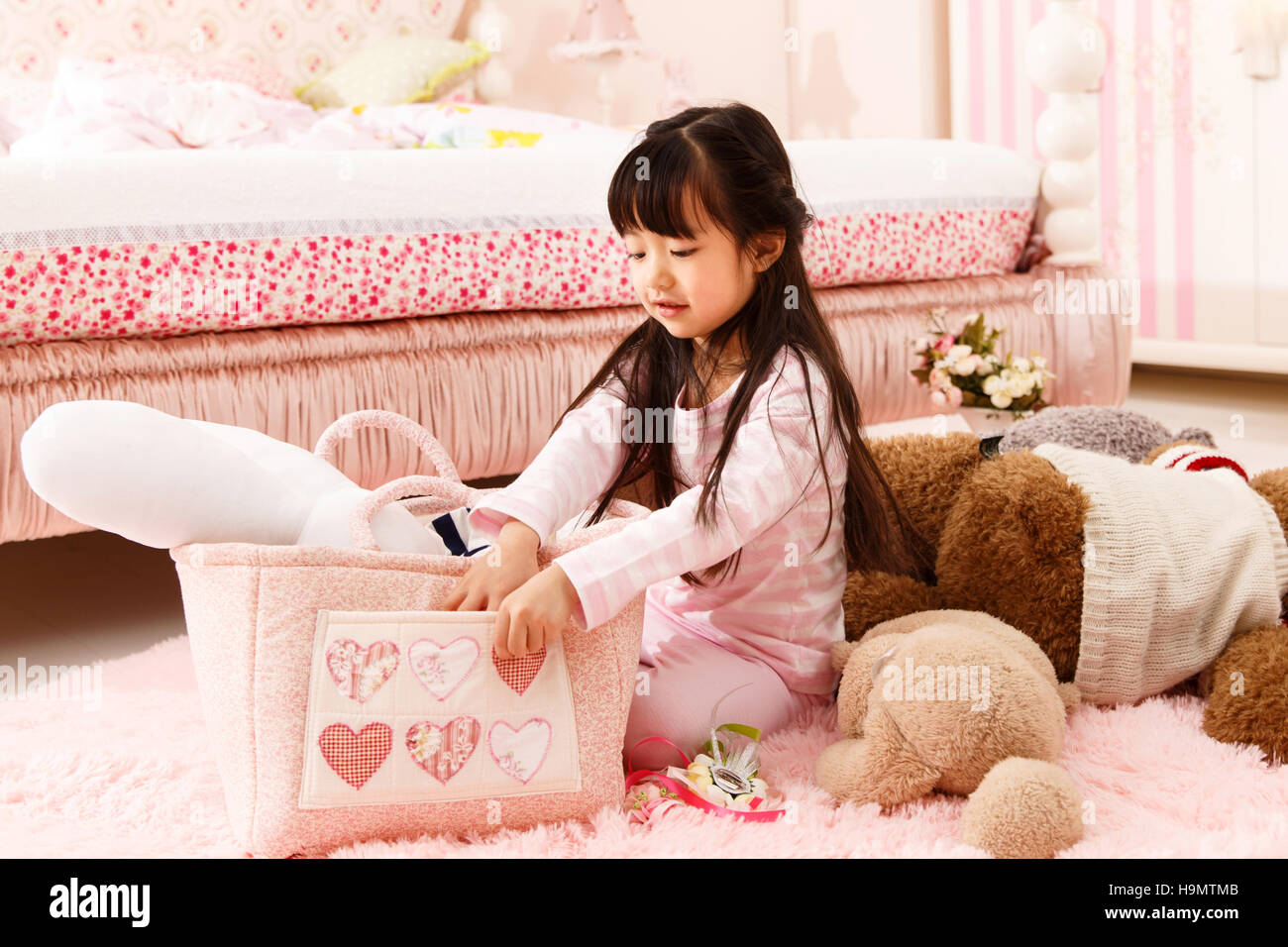 Cute little girl sitting on the rug Stock Photo - Alamy