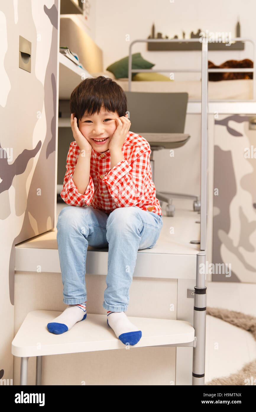 The little boy sat on the steps to play Stock Photo - Alamy