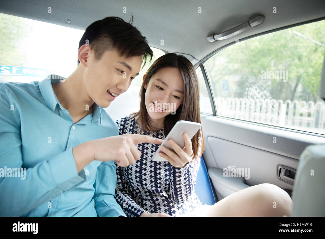 Young lovers in the car to see the phone Stock Photo - Alamy