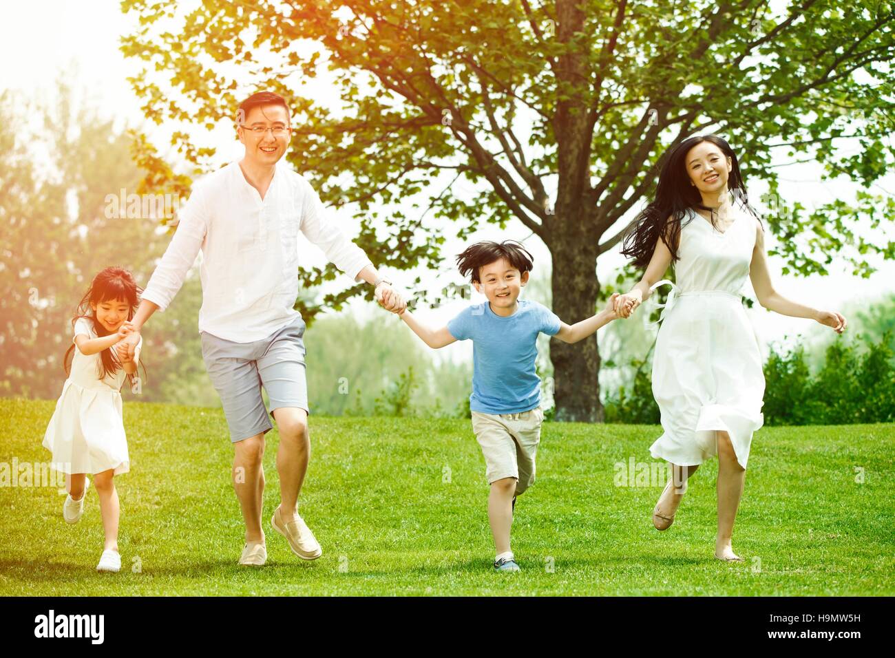 Happy families run on the grass Stock Photo - Alamy