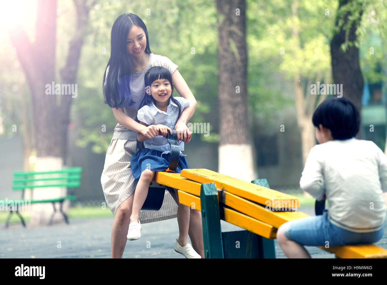 Happy family playing seesaw Stock Photo - Alamy