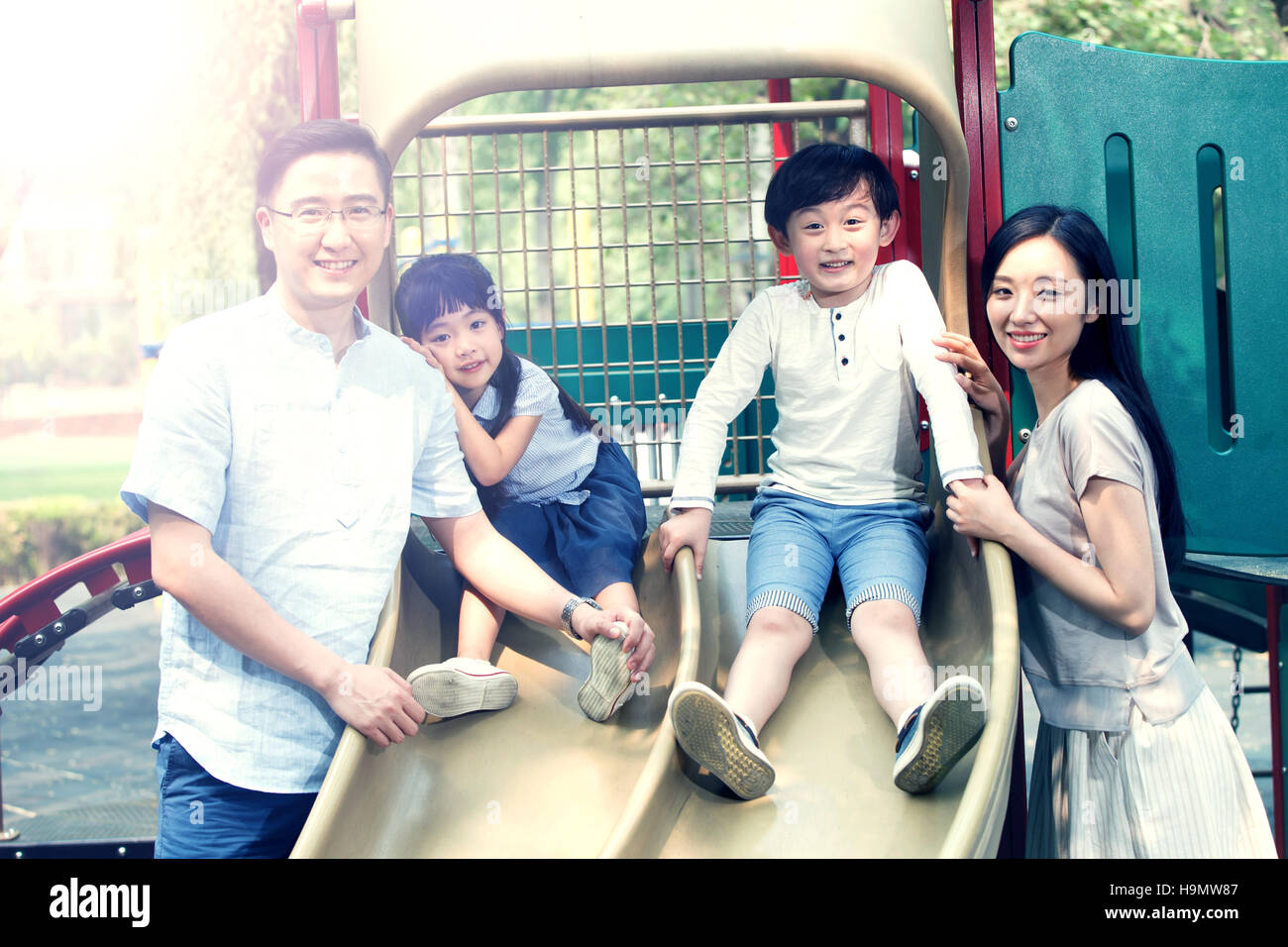 A family of four slides Stock Photo - Alamy