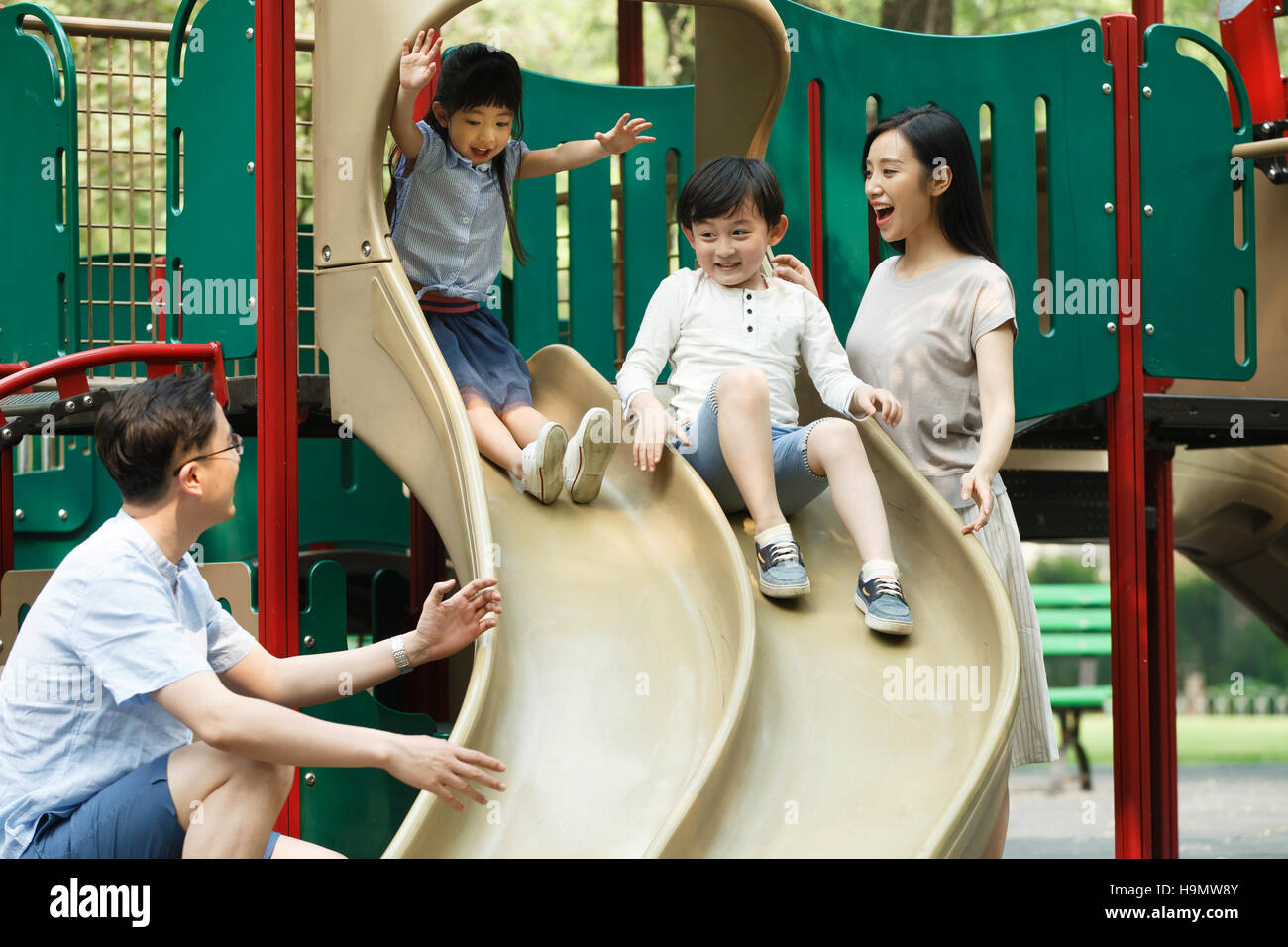 A family of four slides Stock Photo - Alamy
