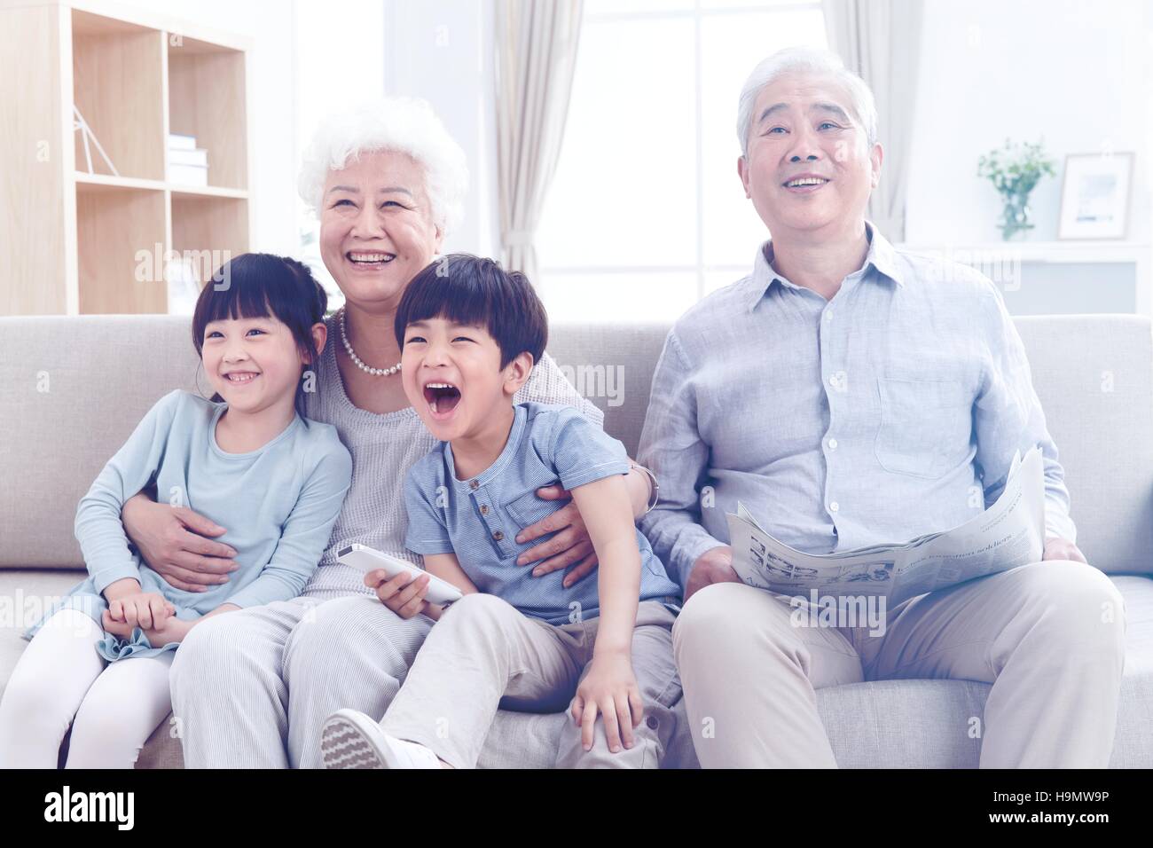 Happy family watching TV in the living room Stock Photo - Alamy