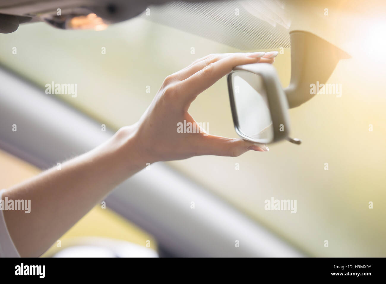 Young woman adjusting a rear-view mirror in the car Stock Photo - Alamy