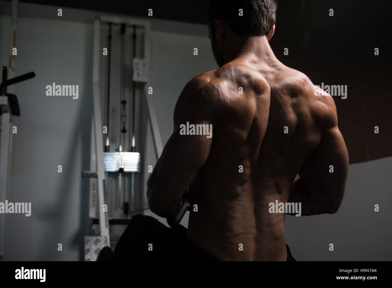 Handsome Bodybuilder Doing Heavy Weight Exercise For Back On Machine ...