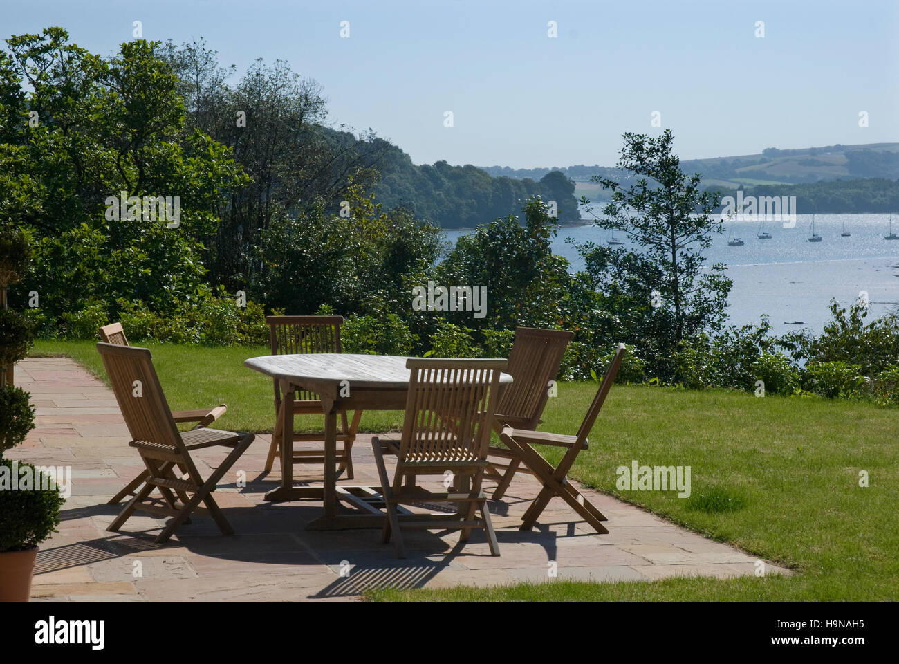 Table and chairs outside in garden overlooking river. Oak, sea view ...
