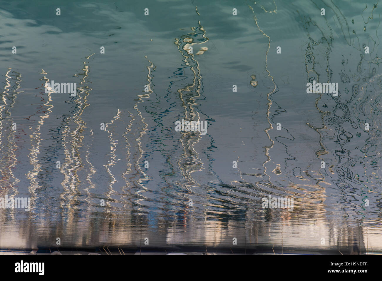 distorted reflection of boats in water at marina Stock Photo - Alamy