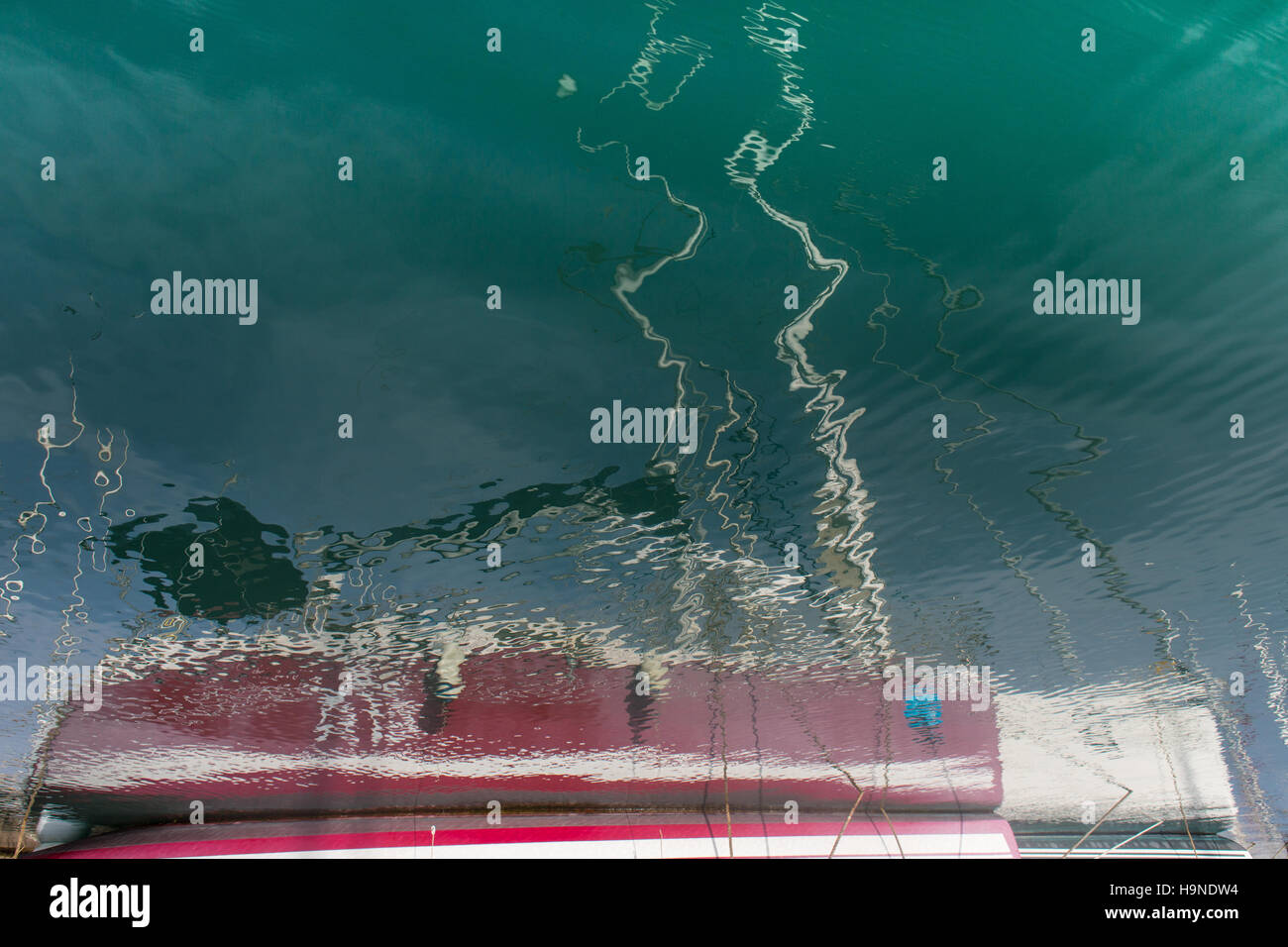 distorted reflection of boat in water at marina Stock Photo - Alamy