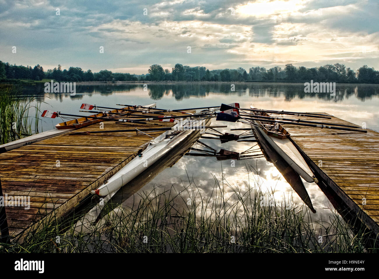 Rowing shells beside dock at sunrise Stock Photo - Alamy