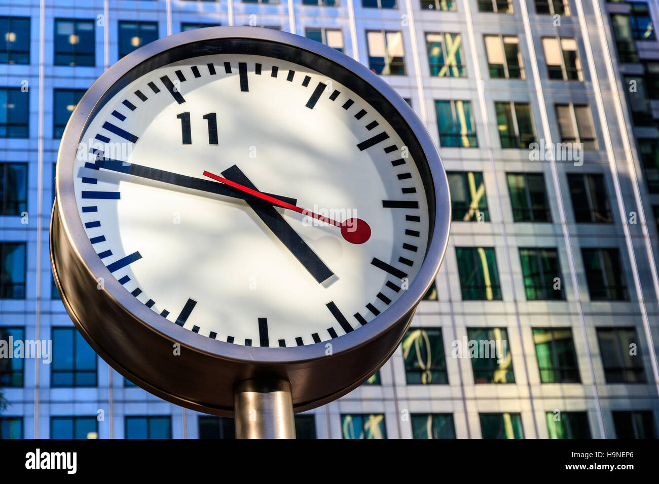 Public clock in Canary Wharf, London against office building Stock ...