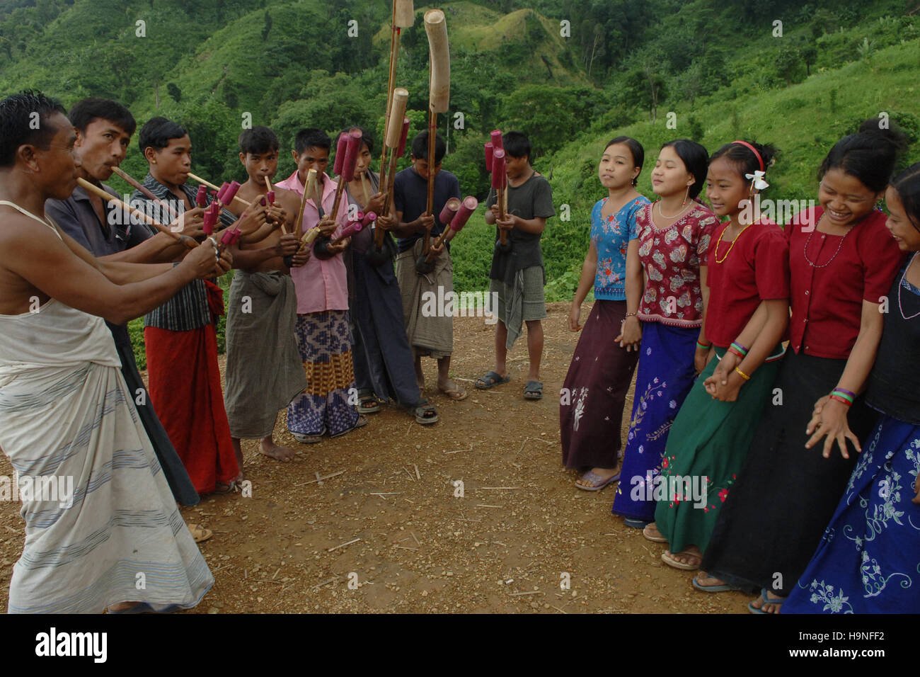 A group of tribal men playing traditional Flute and girls are dancing ...