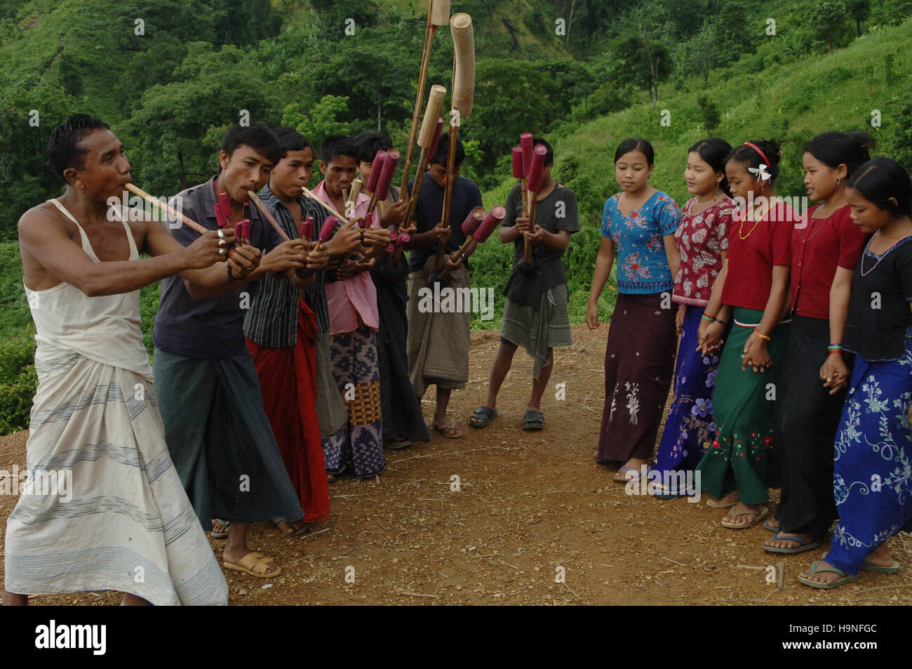 A group of tribal men playing traditional Flute and girls are dancing ...