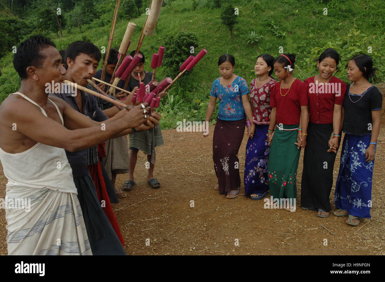 A group of tribal men playing traditional Flute and girls are dancing ...