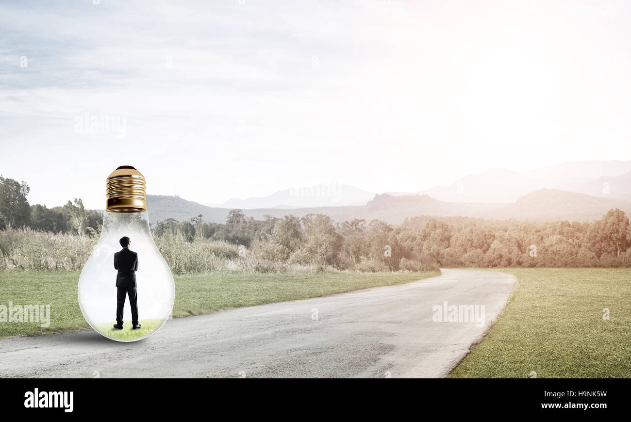 Businessman inside light bulb Stock Photo - Alamy