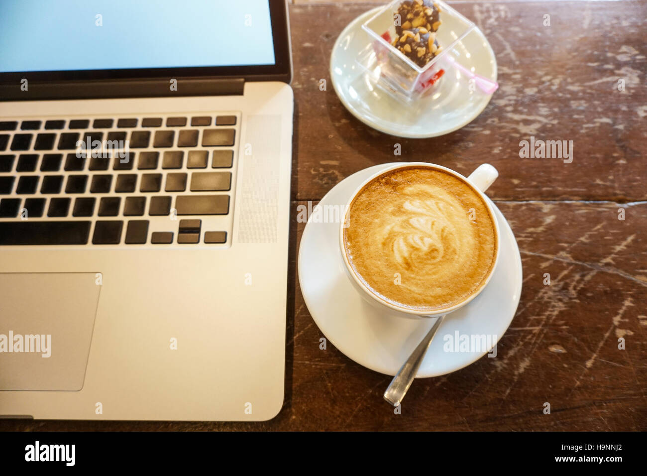 Coffee and laptop working in coffee shop and sun light Stock Photo - Alamy