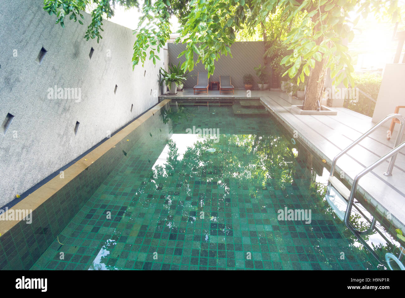 Swimming pool in the hotel with sun light Stock Photo - Alamy