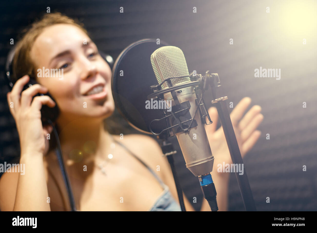 girl singing into a microphone in studio Stock Photo - Alamy