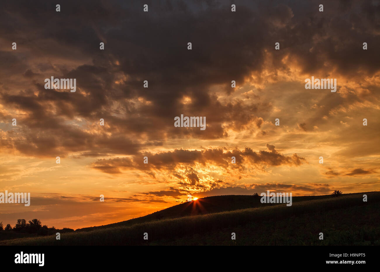 the sun sets over the mountain Stock Photo - Alamy