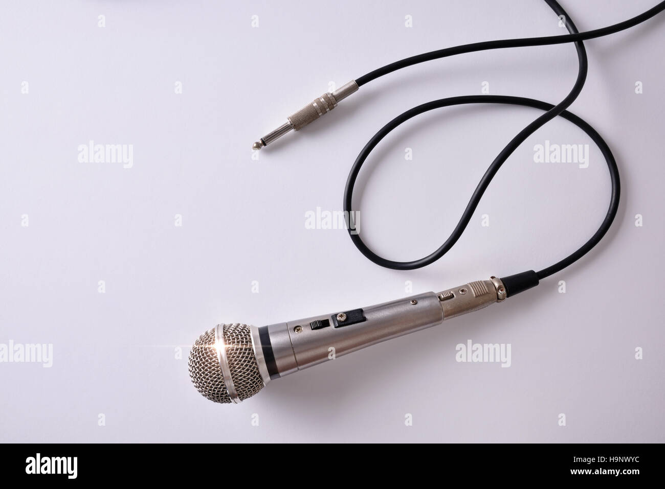 Wired microphone with jack connector on white table. Top view ...