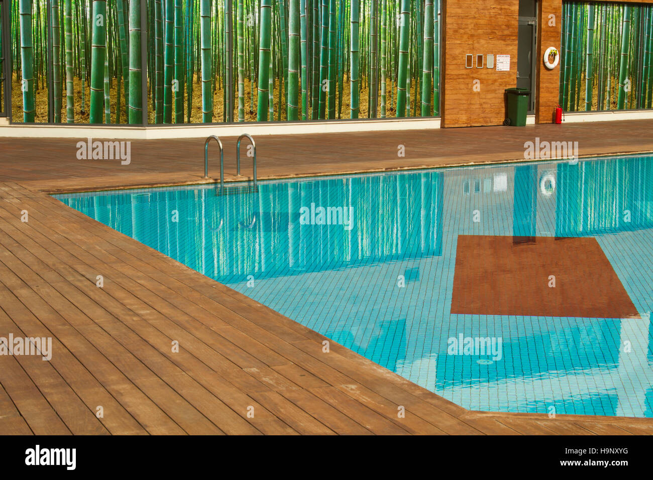 Swimming pool with old wooden flooring and blue water Stock Photo - Alamy